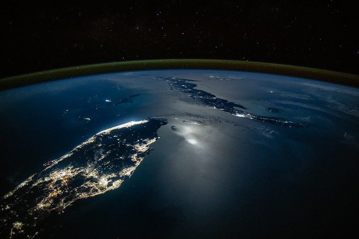 City Lights Glow Along Moonlit Waters - NASA Science
