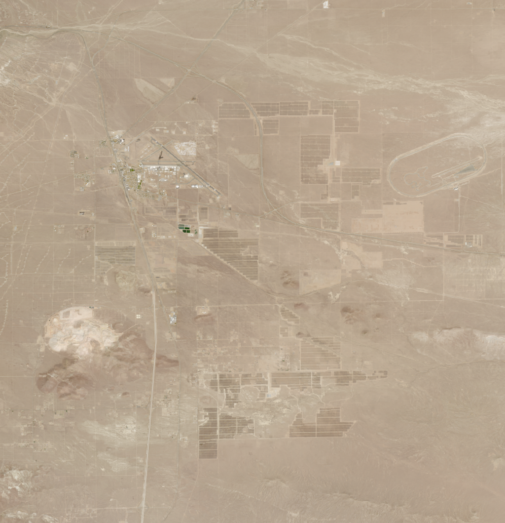 A view from orbit above the Mojave desert in California, and a large field of solar panels is visible in multiple clusters.